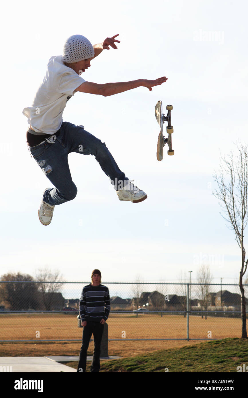 Teenage boy flying high out of concrete skate park bowl Stock Photo - Alamy