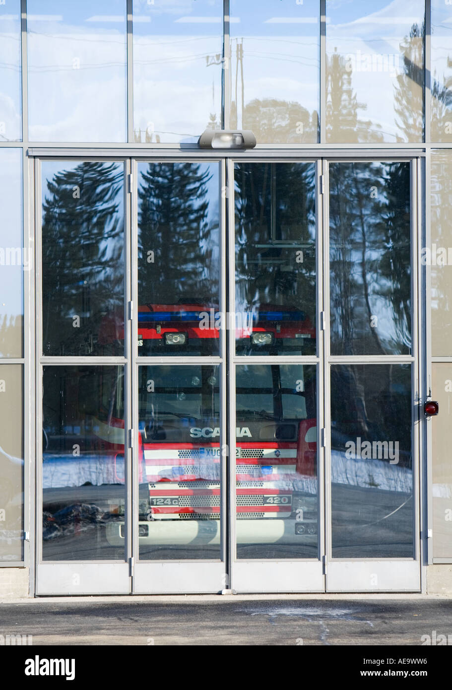 Fire department truck behind closed garage glass doors, forest ...