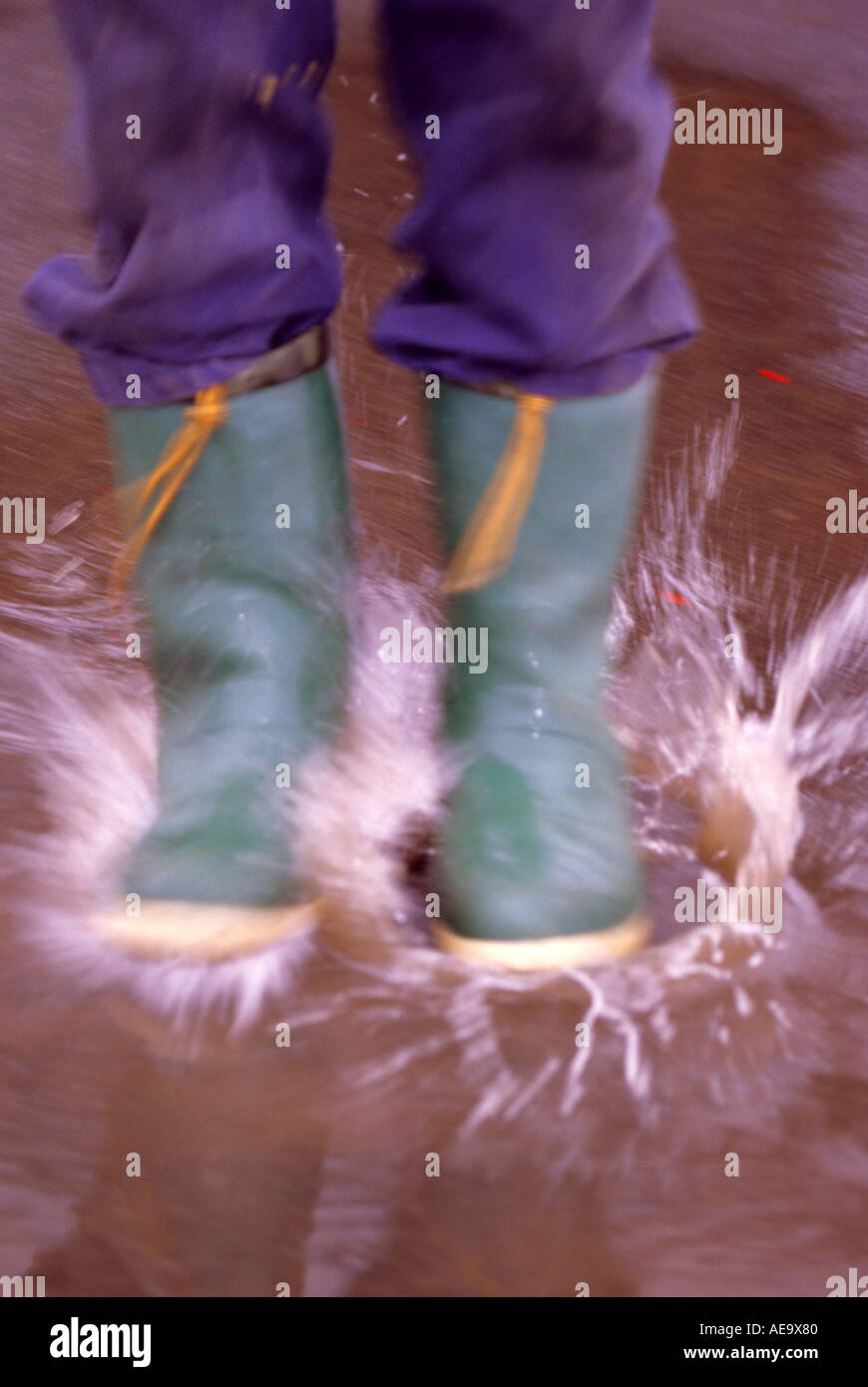 Boots splashing in a puddle of water Stock Photo - Alamy