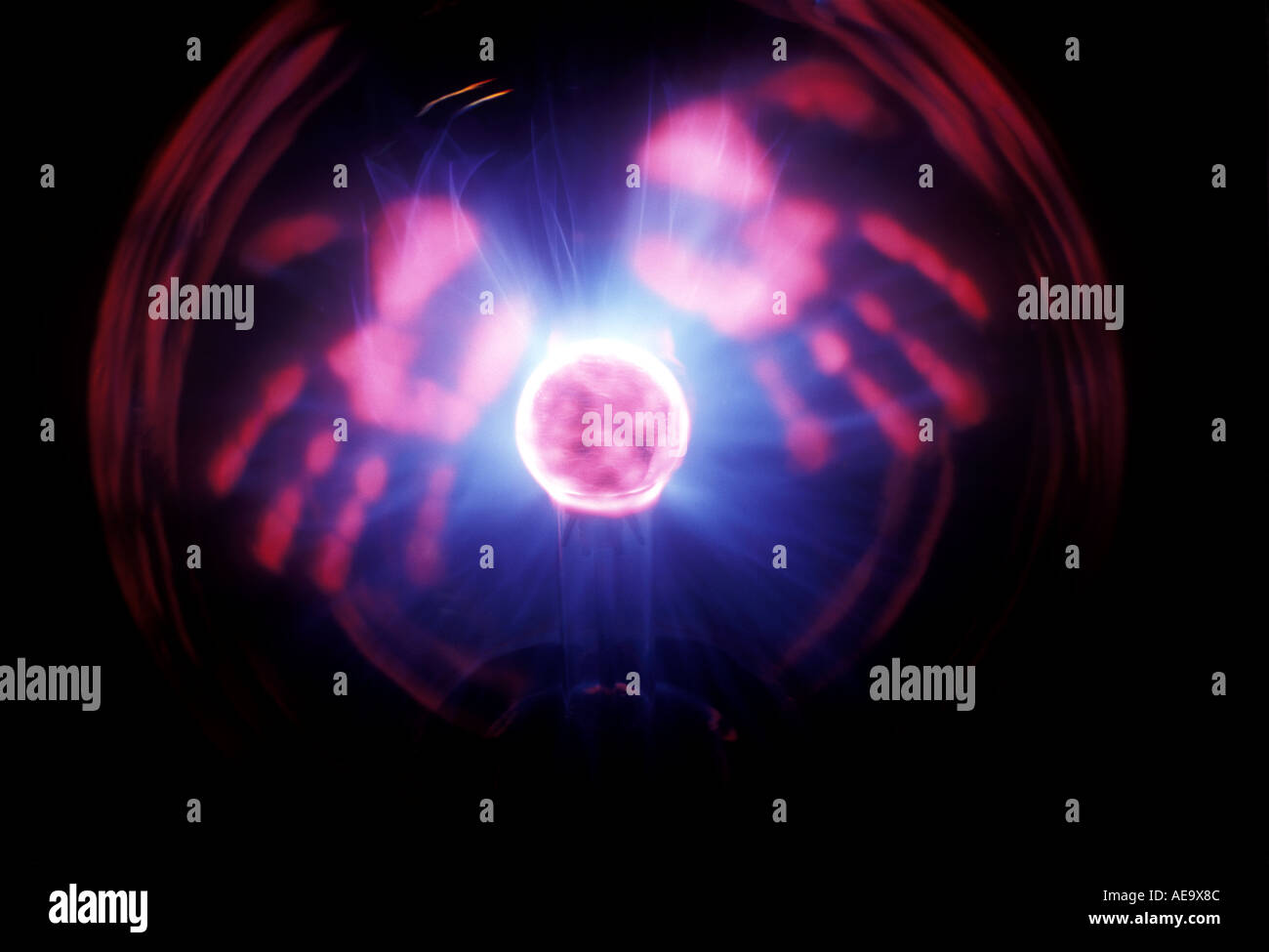 plasma ball with static electricity two hands glowing purple behind ...
