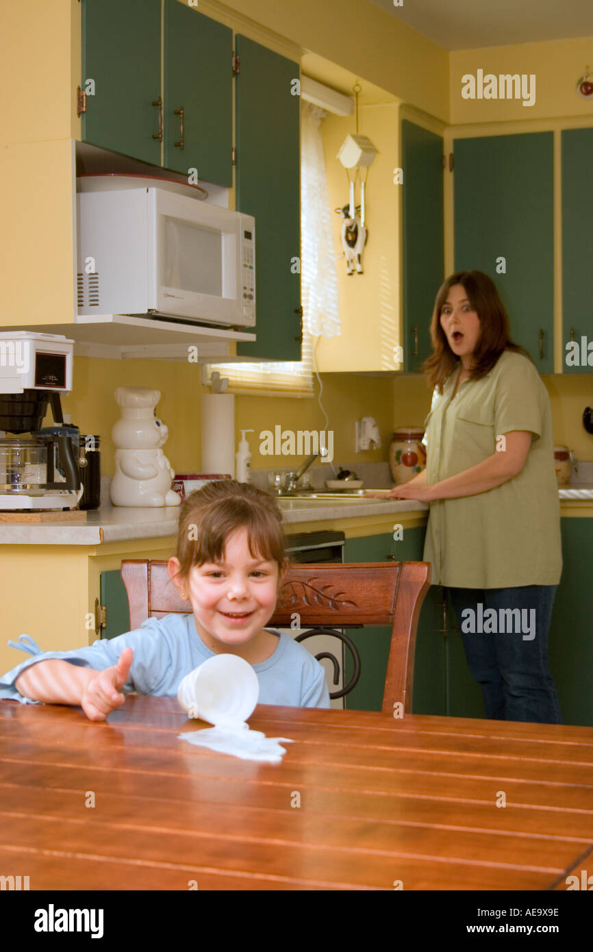 Child spilling milk with mother looking shocked in background Stock ...