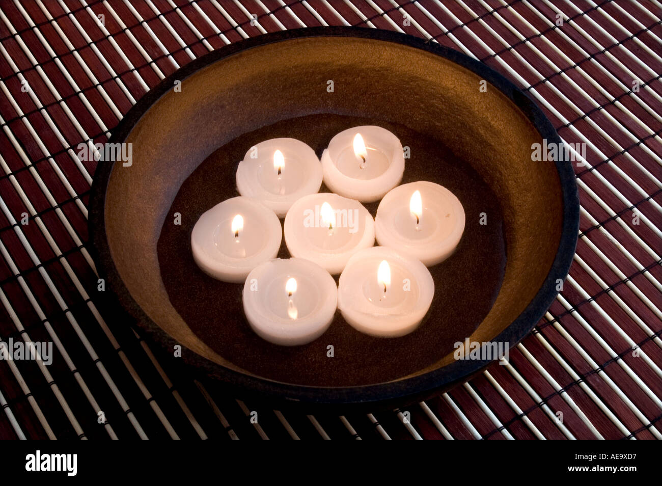 tea light candles grouped together lit against dark background one ...