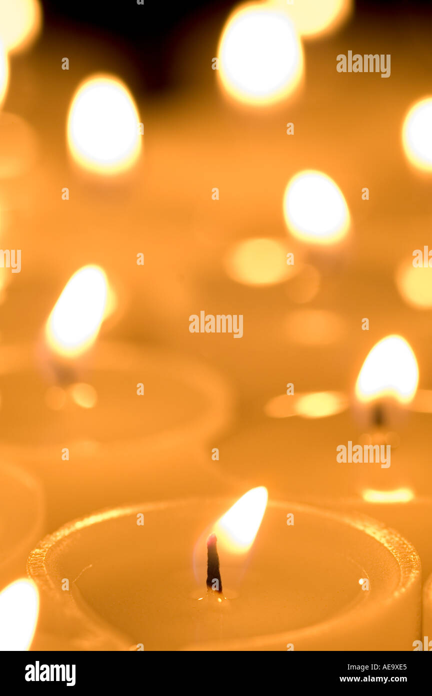 tea light candles grouped together lit against dark background one ...