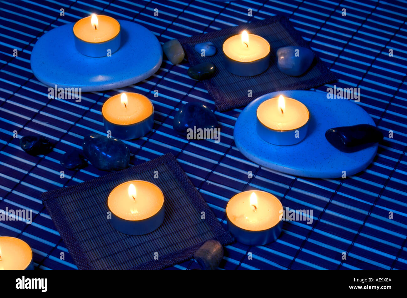 tea light candles grouped together lit against dark background one ...