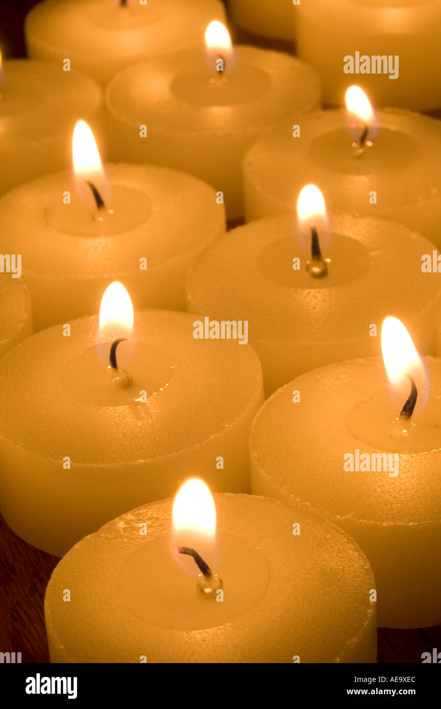tea light candles grouped together lit against dark background one ...