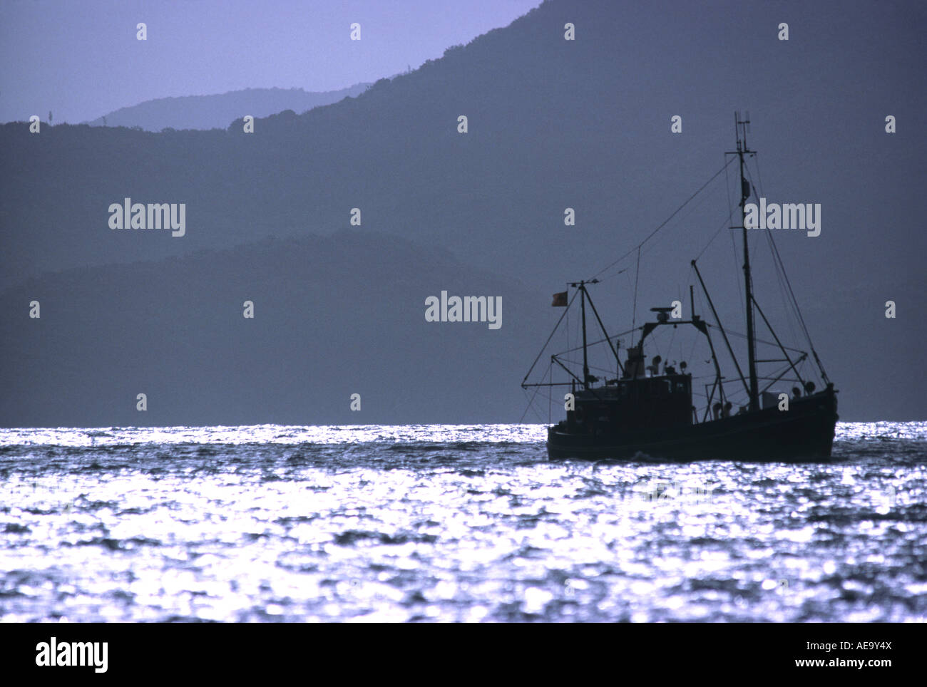 A fishing trawler is seen silhouetted against the Island of St. Thomas ...