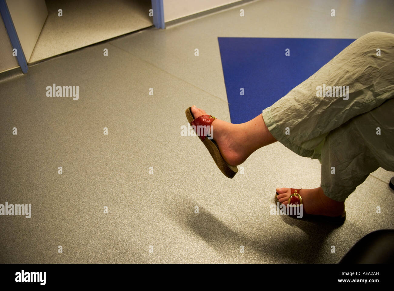 a cropped view of woman's crossed legs and feet pointing towards an ...