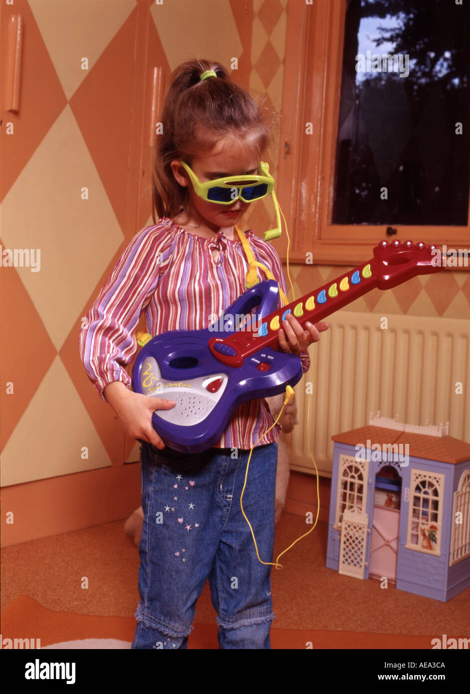 Little girl playing at being a pop rock star in her playroom Stock ...