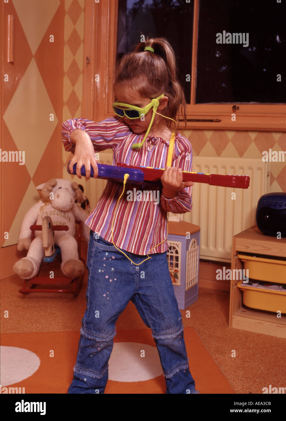 Little girl playing at being a pop rock star in her playroom Stock ...