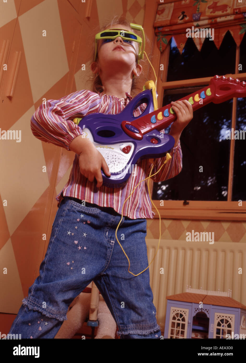 Little girl playing at being a pop rock star in her playroom Stock ...