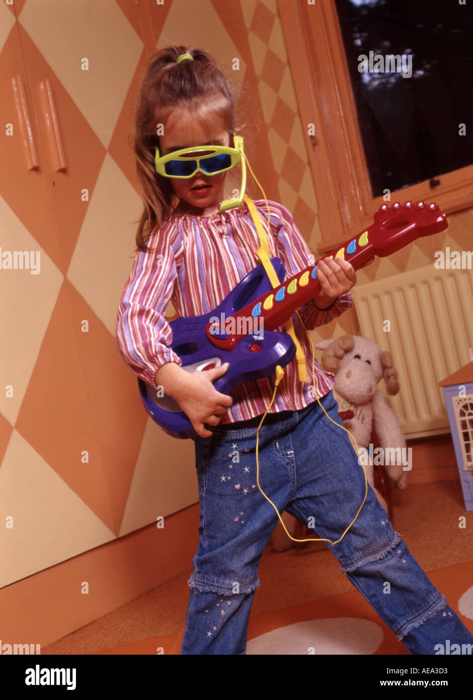 Little girl playing at being a pop rock star in her playroom Stock ...