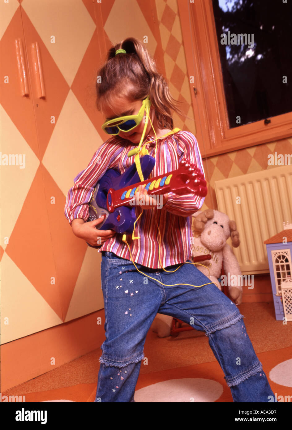 Little girl playing at being a pop rock star in her playroom Stock ...