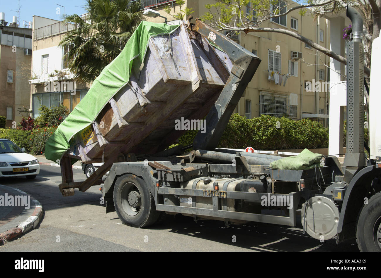 Truck loading a full covered container of building material waste Stock ...