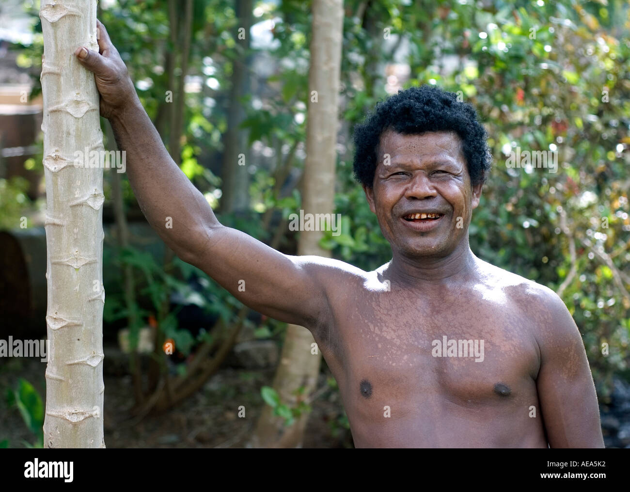 Portrait of a Papuan man in the jungle on the shore of the Sentani lake ...