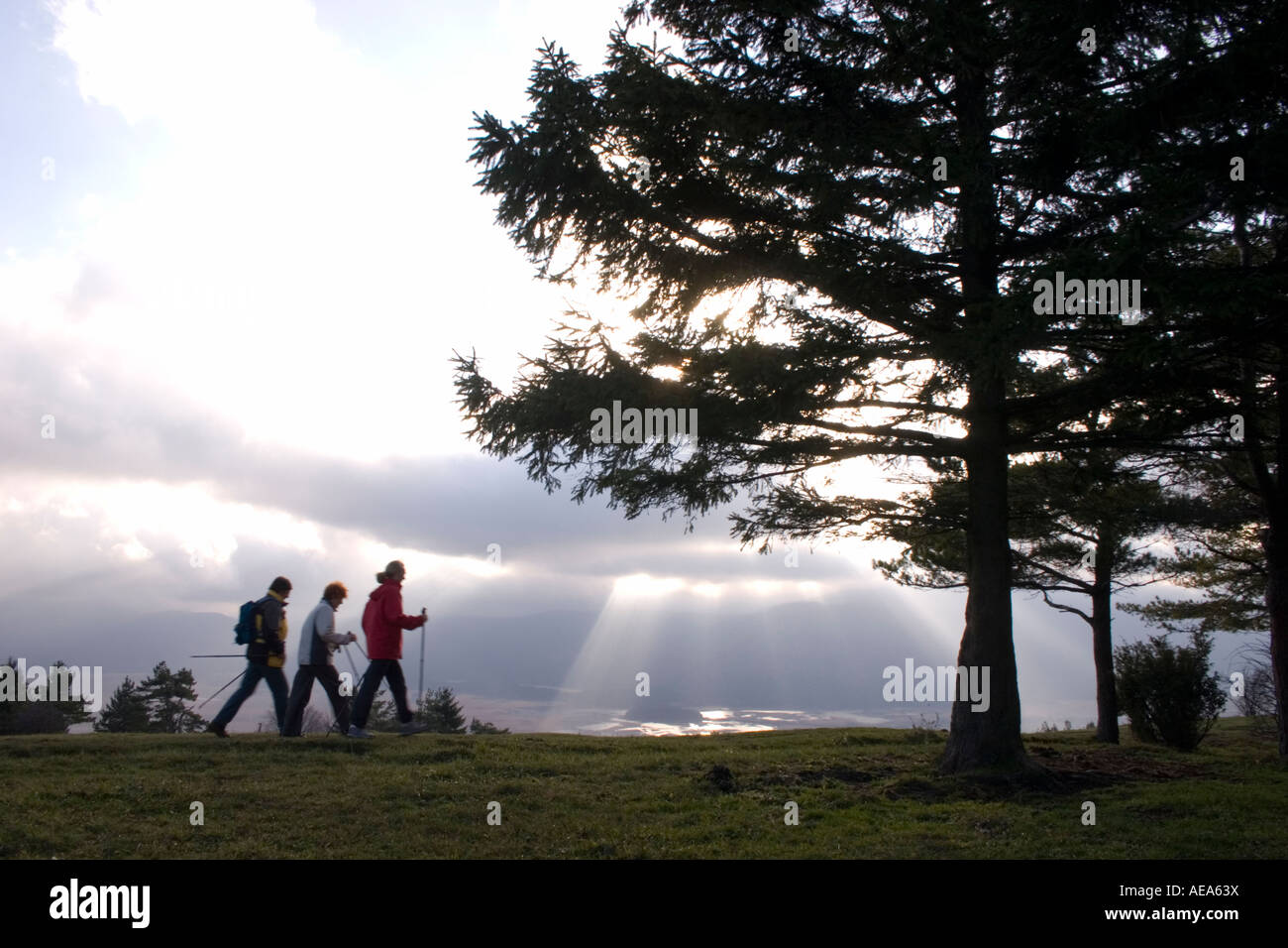 Hikers on Slivnica Mountain as sun goes down over Cerknica Lake ...