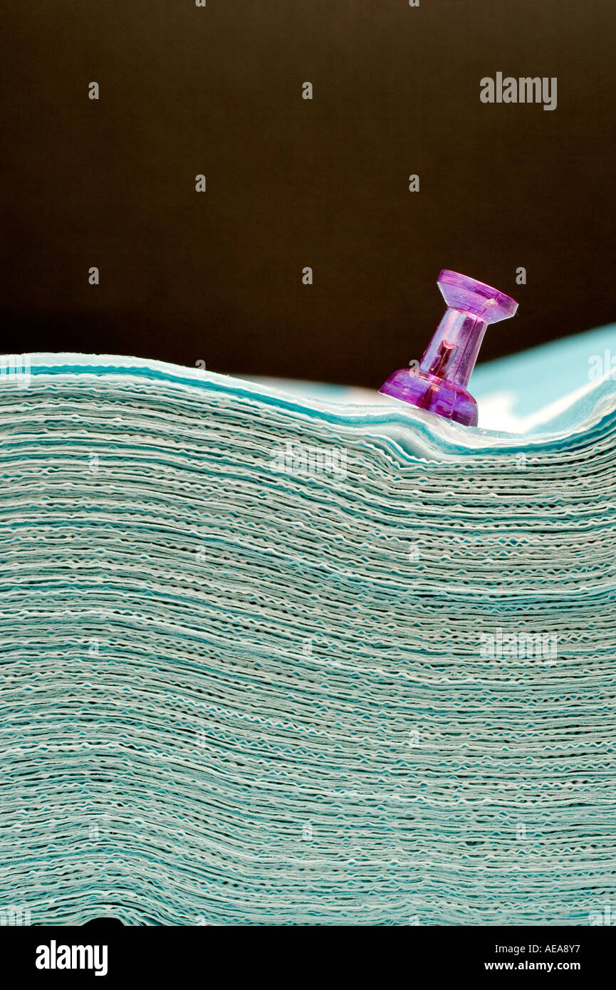 Purple paper pin and a stack of paper Stock Photo - Alamy