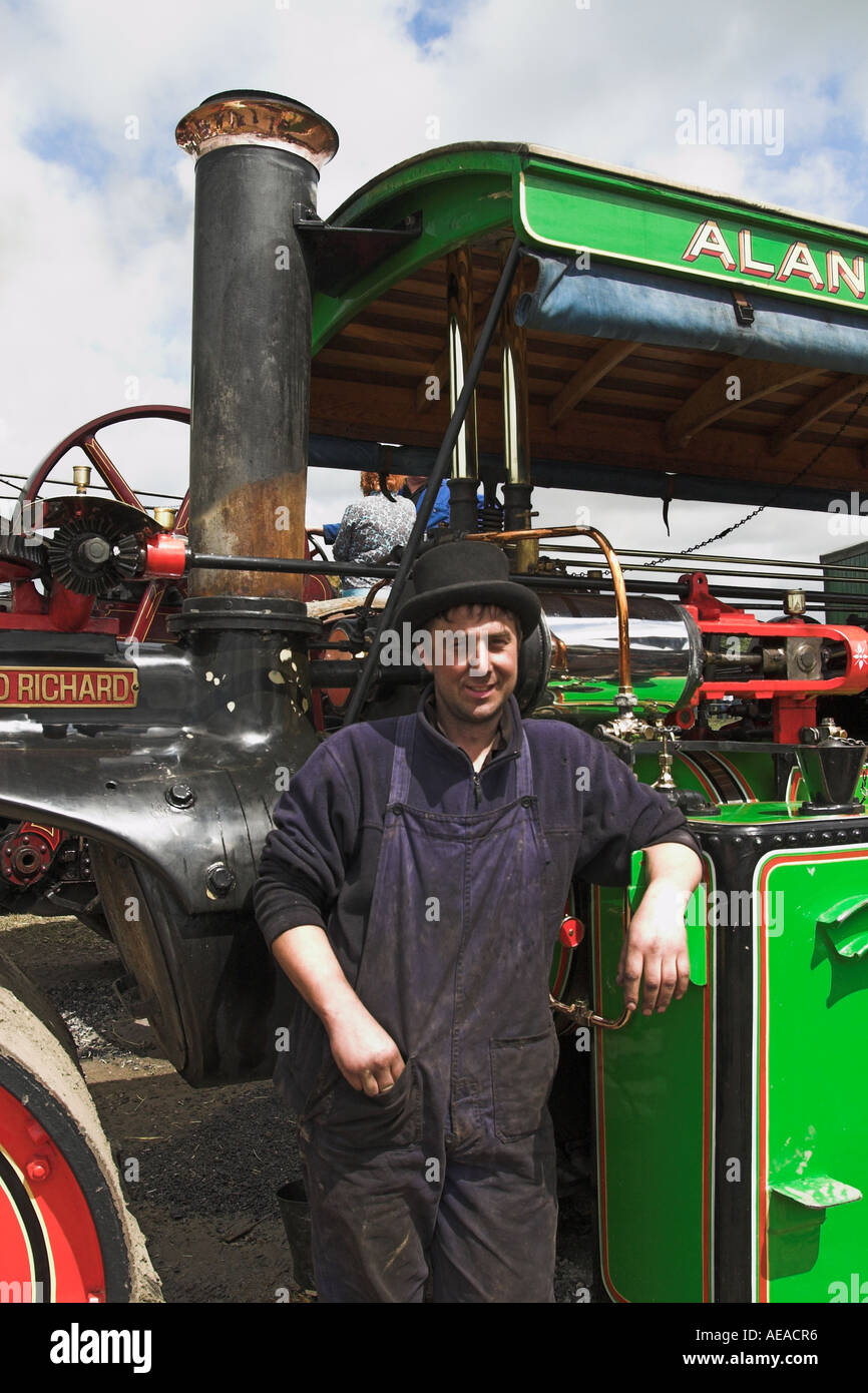 Proud exhibitor, in bowler hat and overalls, of a green traction engine ...
