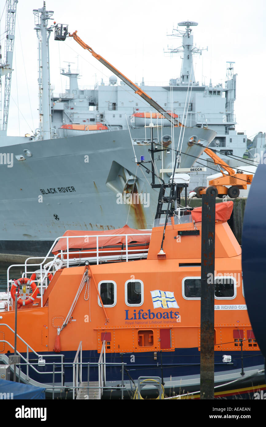 a life boat docked in front of a navy warship Stock Photo - Alamy