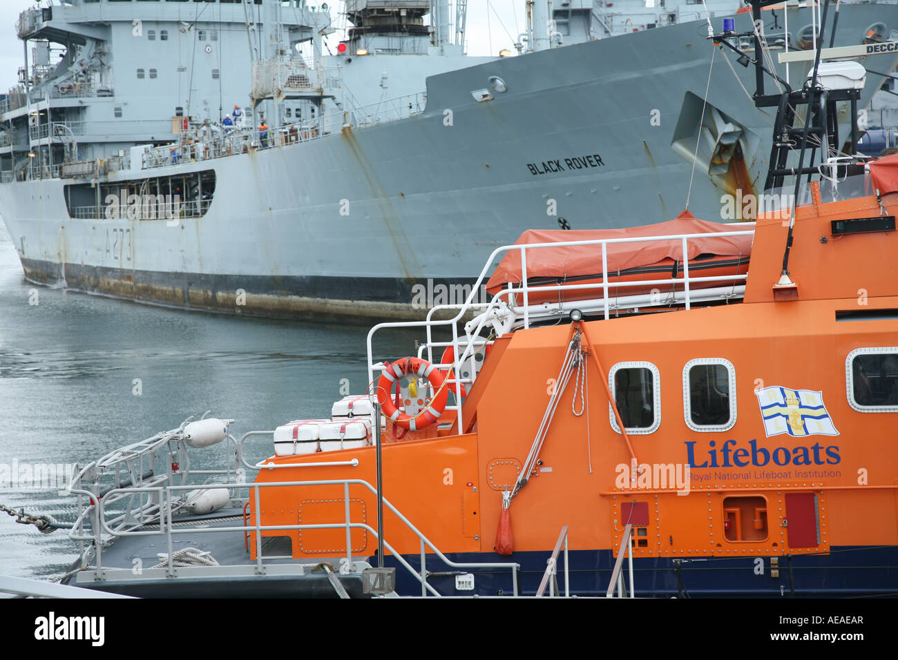 a lifeboat moored in front of a royal navy battle ship Stock Photo - Alamy