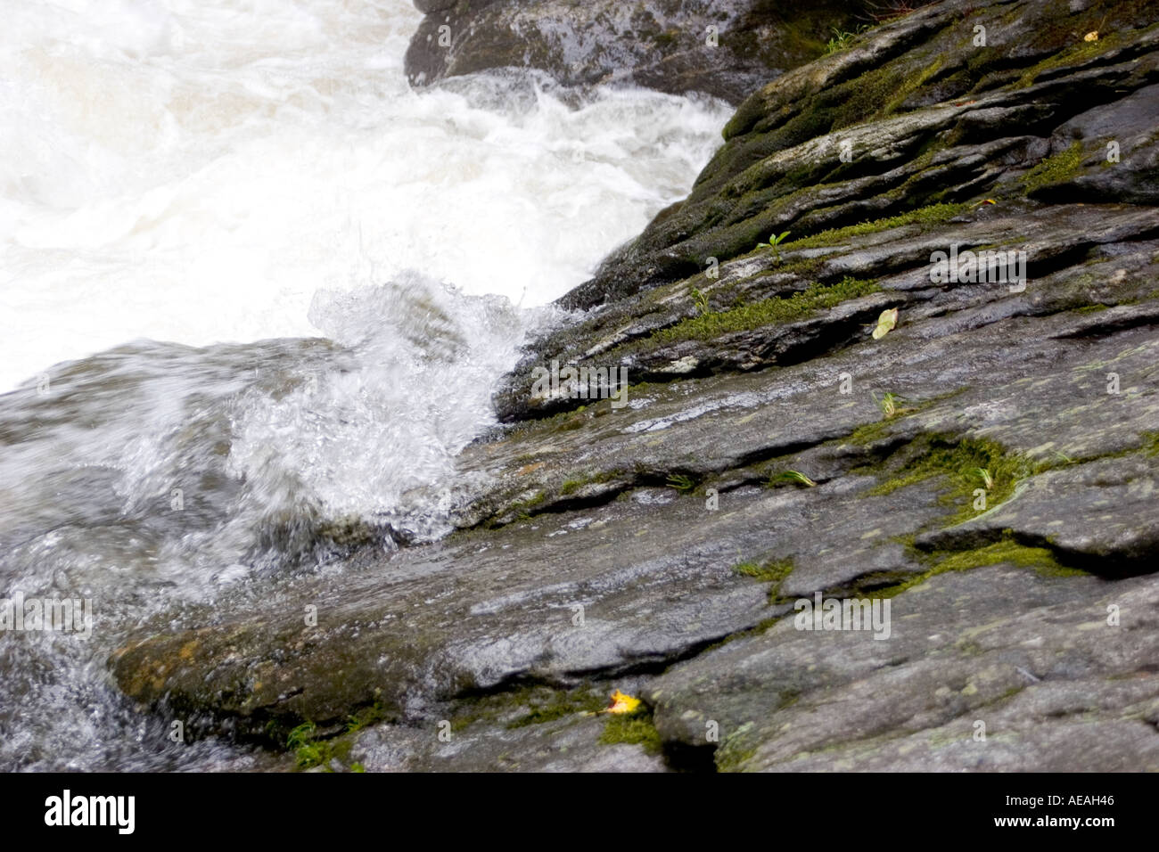 Edge of River bank with ragged rocks and rushing water from the ...