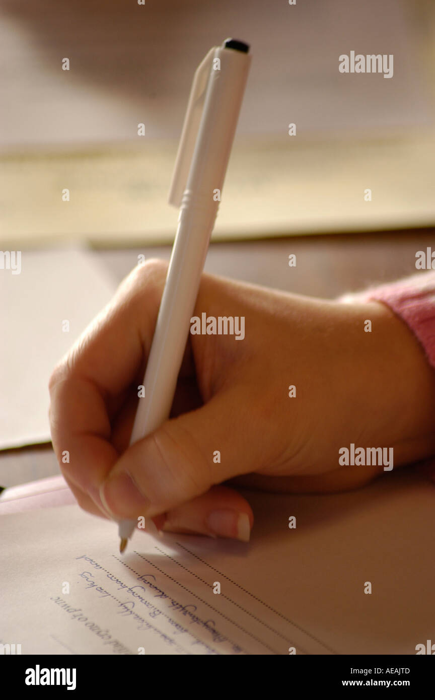 close up of a woman person hand holding a biro pen writing notes in a ...