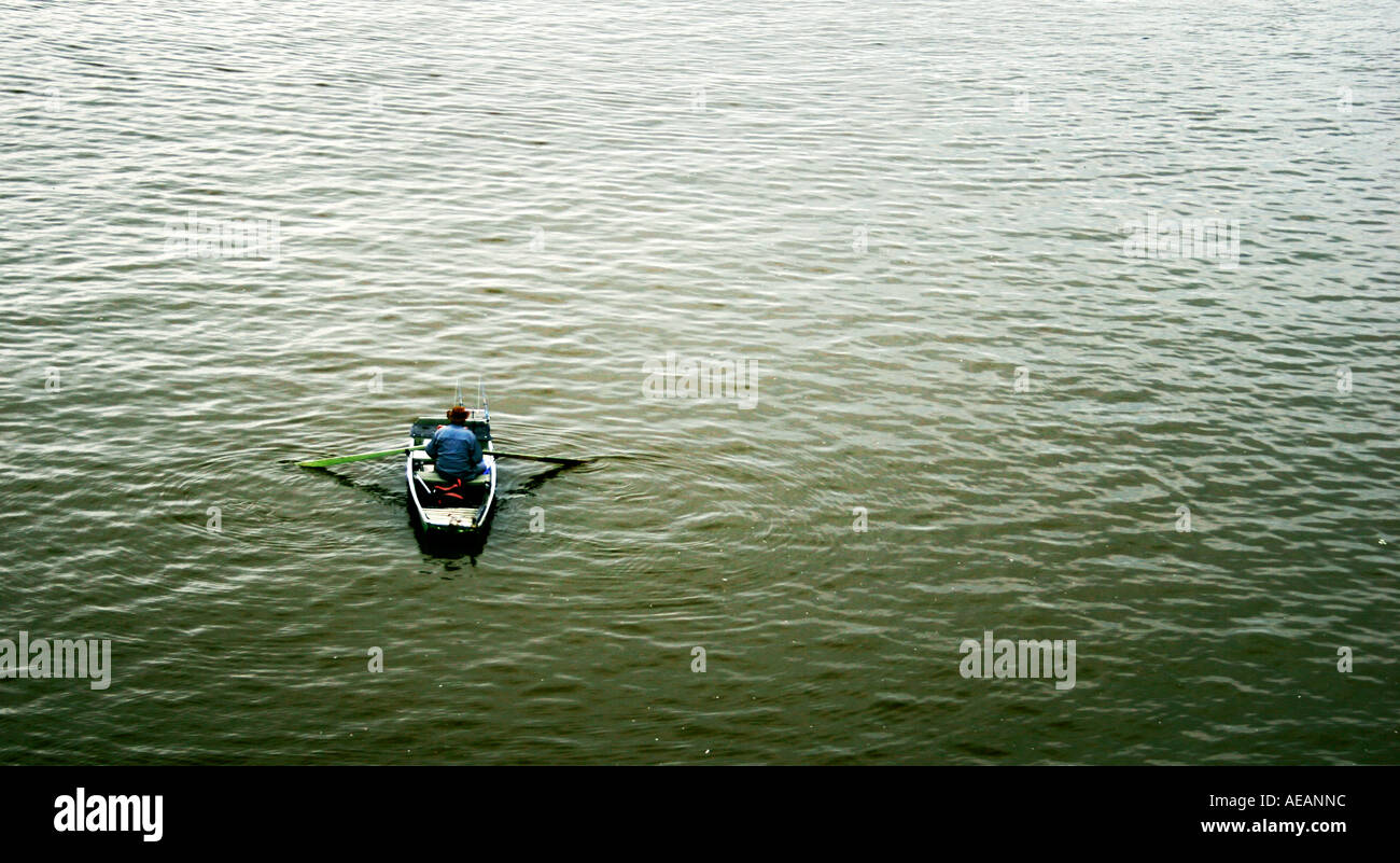 man alone in row boat surrounded by water Stock Photo - Alamy