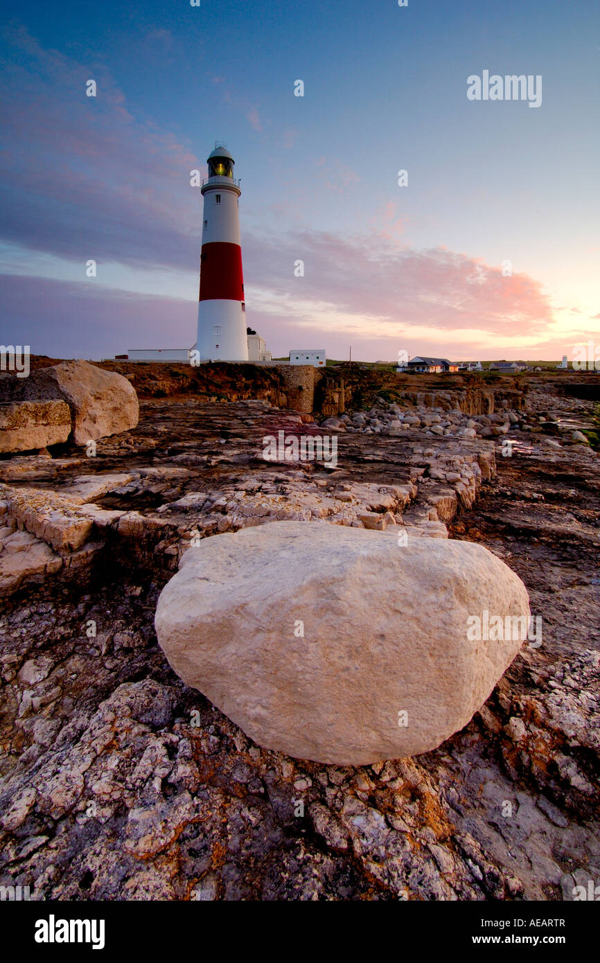Portland Bill lighthouse just before dawn with a large portland stone ...