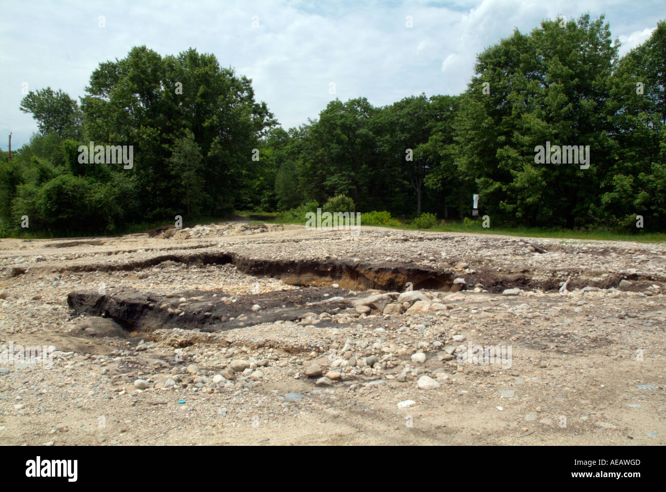 A section of washed out road from water over flowing a small pond Stock ...