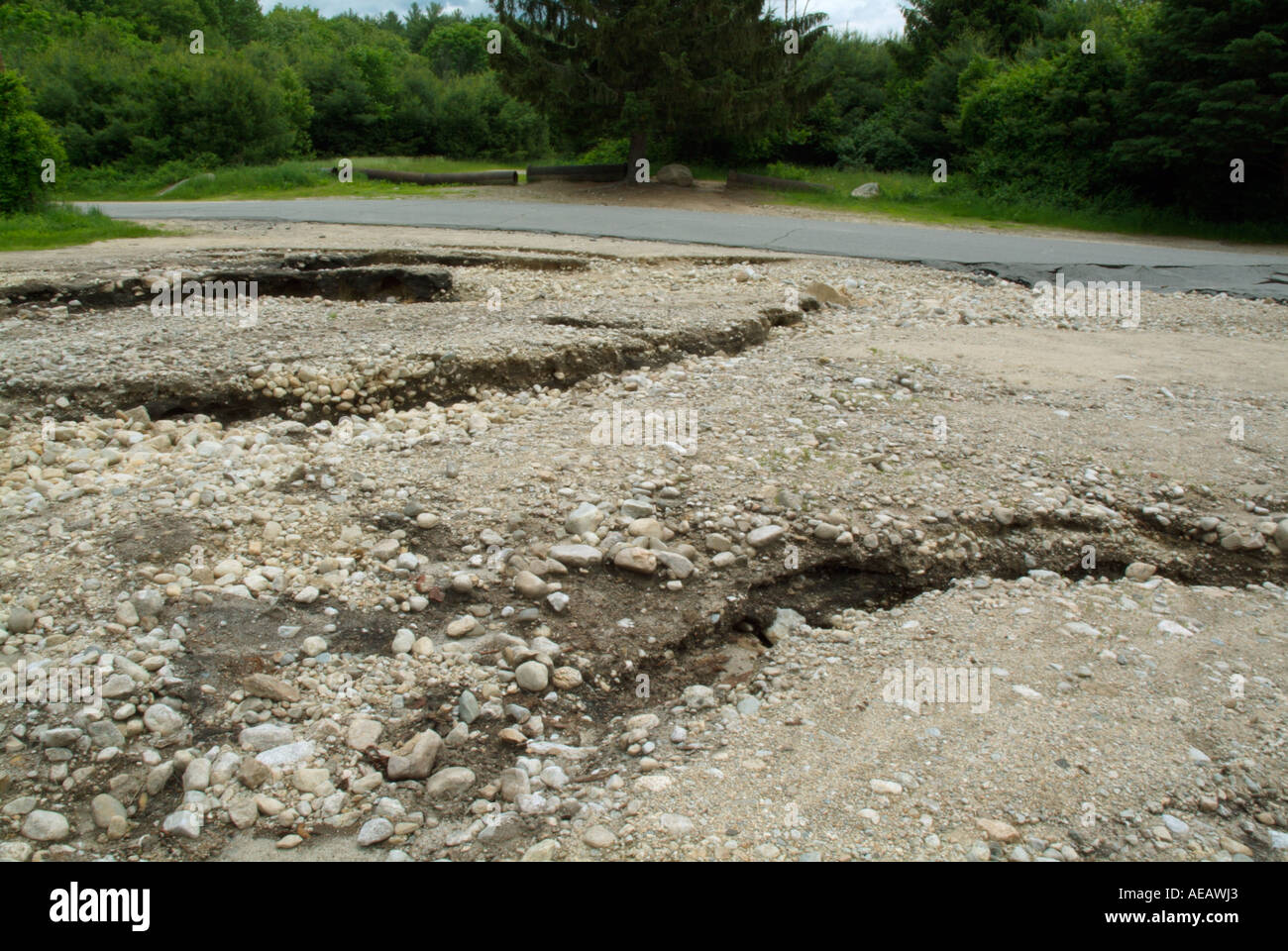 A section of washed out road from water over flowing a small pond Stock ...