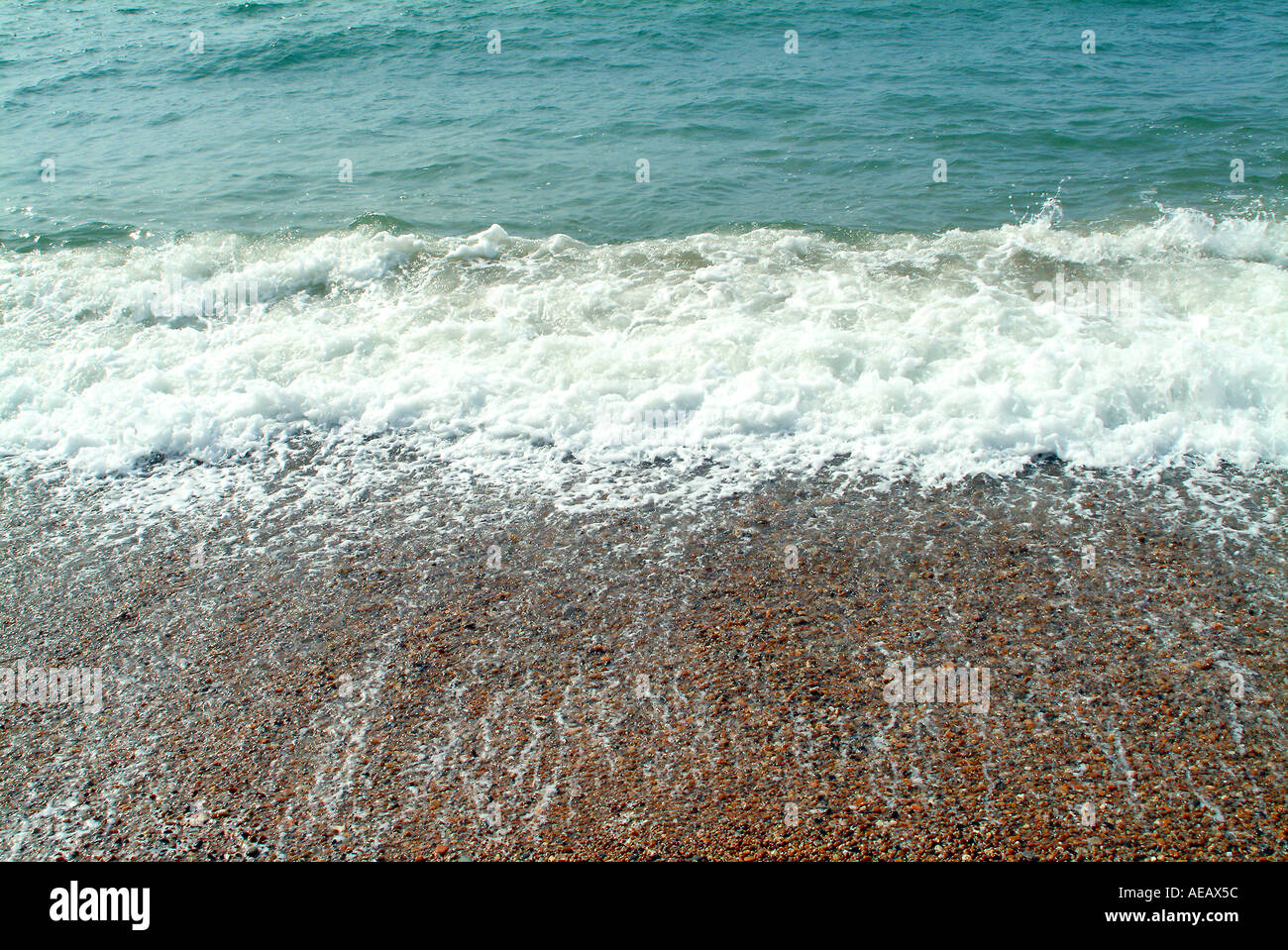 Waves breaking on a shingle beach on the south coast of the UK Stock ...