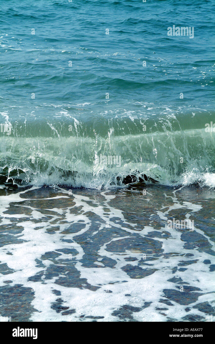 Waves breaking on a shingle beach on the south coast of the UK Stock ...