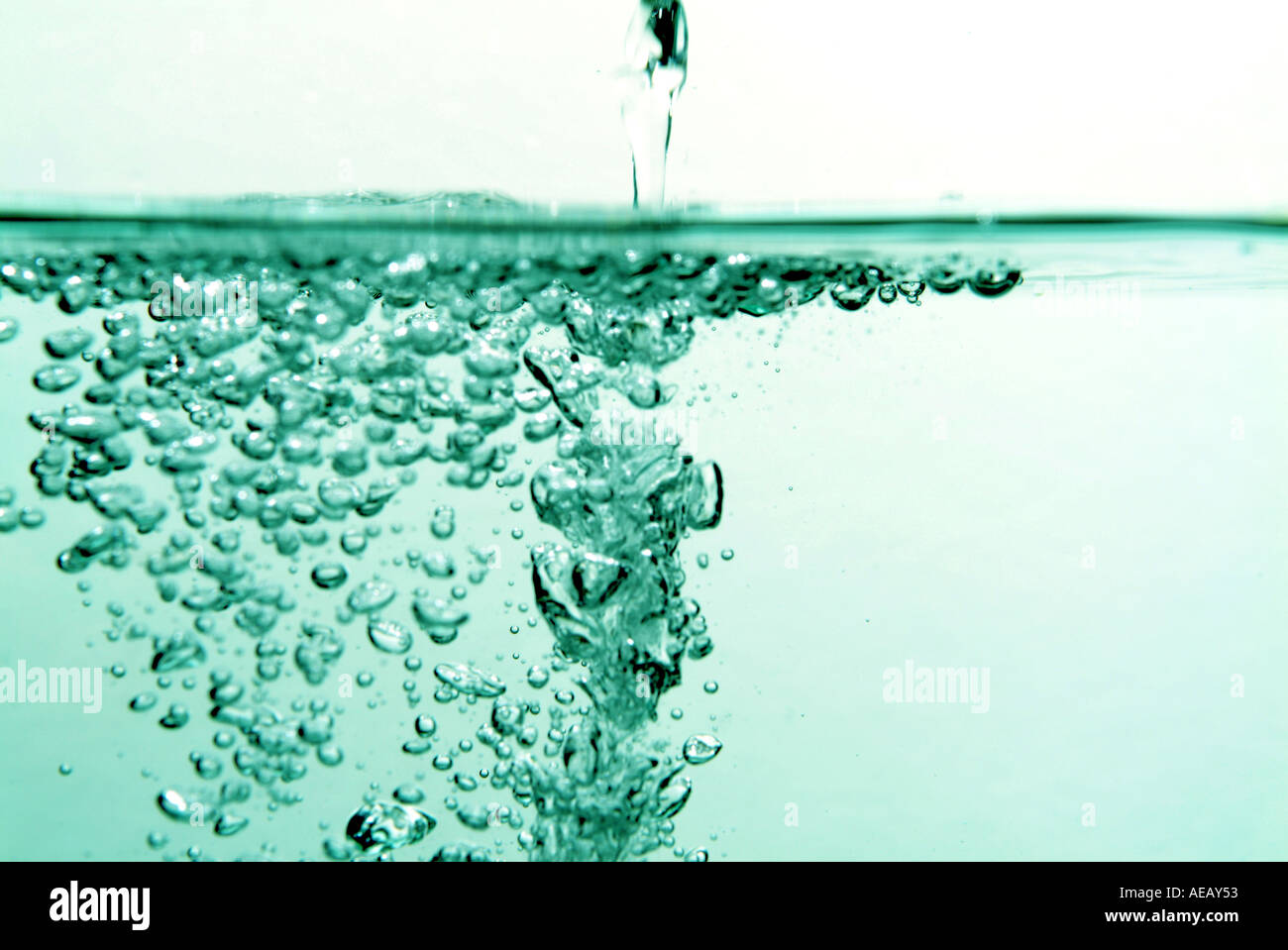 Stream of bubbles created by a stream of water being poured into water ...