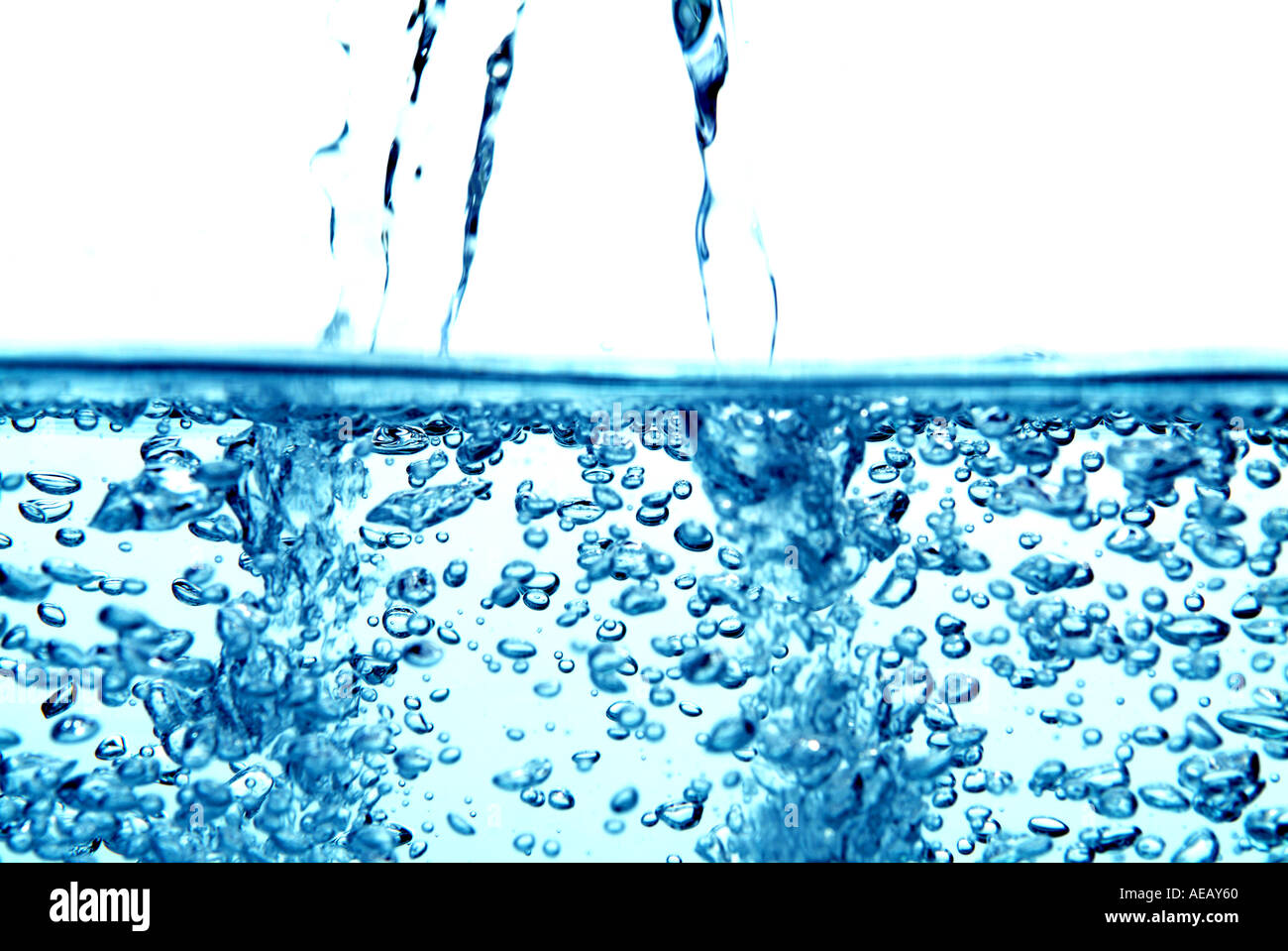 Stream of bubbles created by a stream of water being poured into water ...
