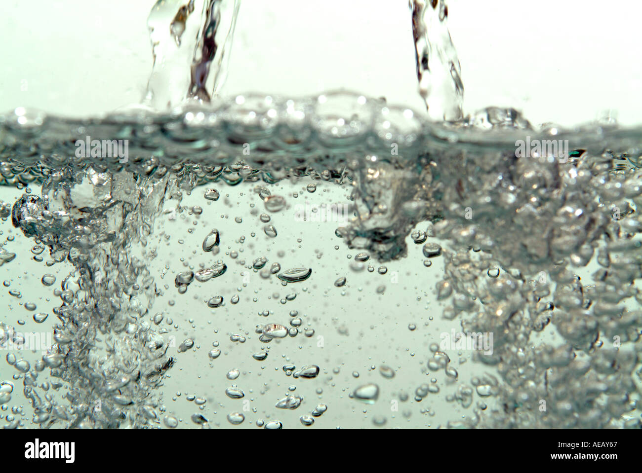 Stream of bubbles created by a stream of water being poured into water ...
