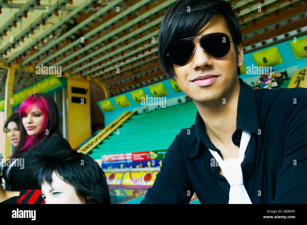 Punk Hispanic teenager sitting with friends in carnival booth Stock ...