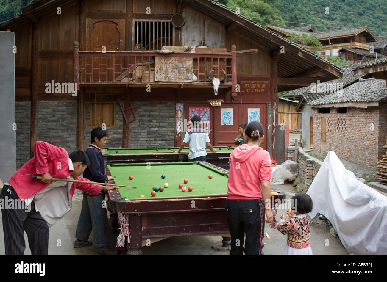 Young peope play pool outdoors at a village of the Baima people in ...