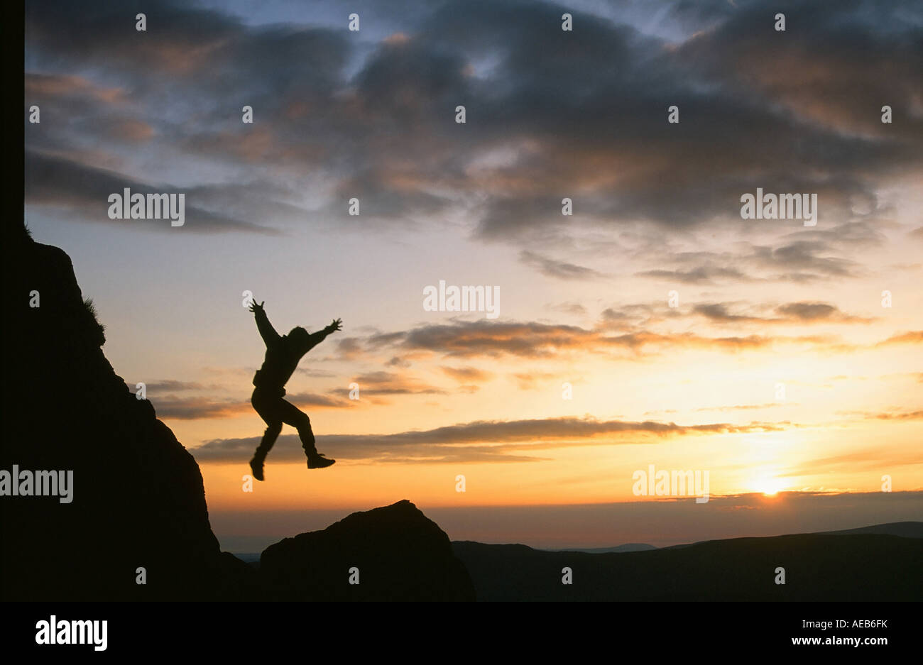 A climber leaping down a crag on Harter Fell, Lake district National ...