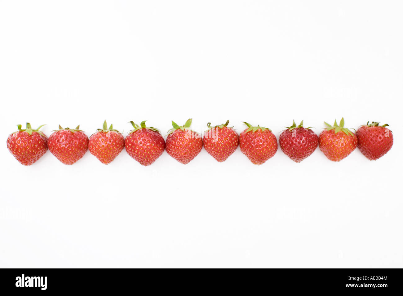 Line of strawberries on white Stock Photo - Alamy