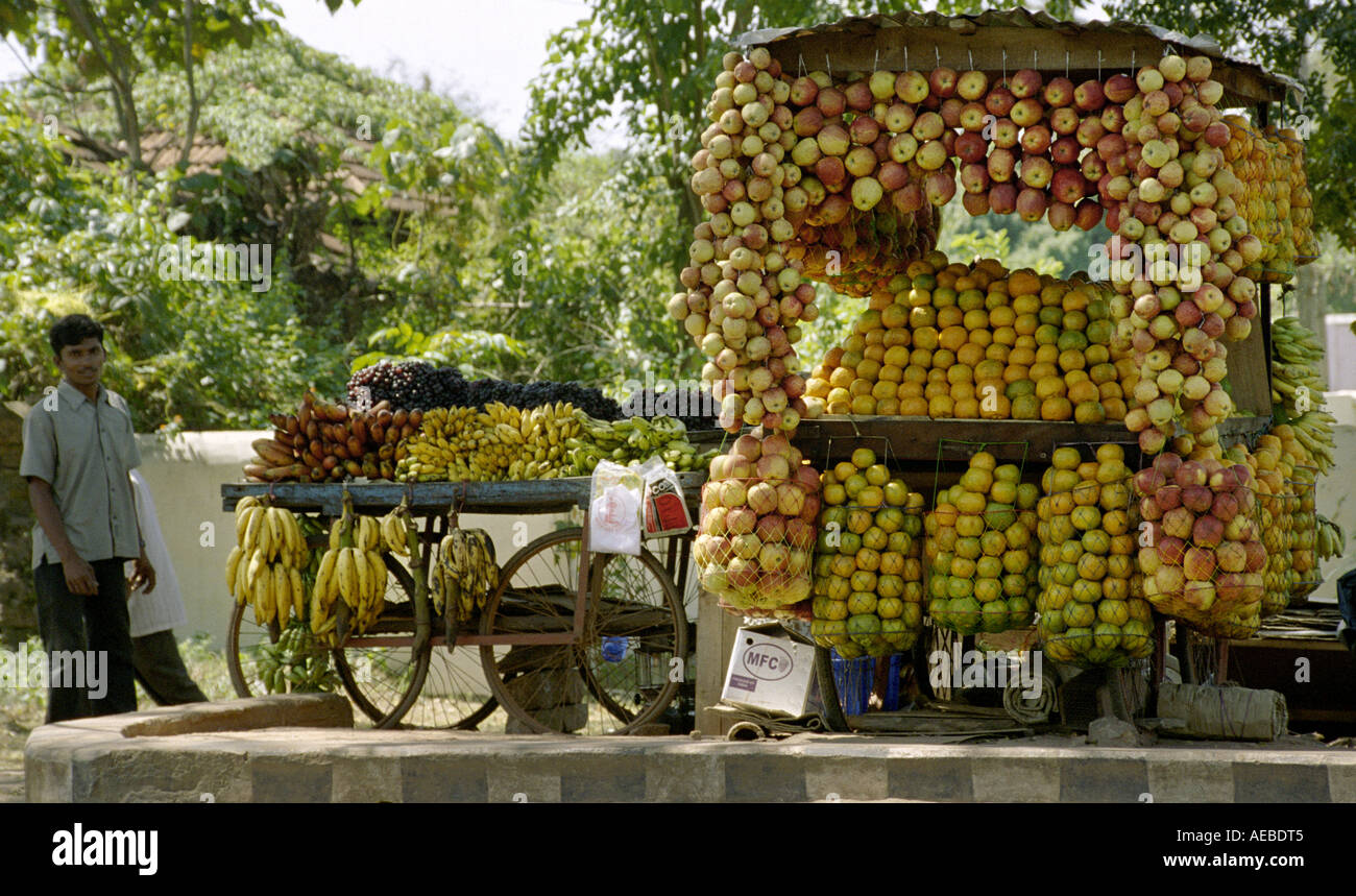 A thickly packed road-side fruit stall with brightly coloured oranges ...