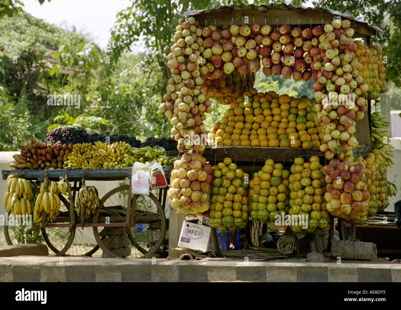 A thickly packed road-side fruit stall with brightly coloured oranges ...