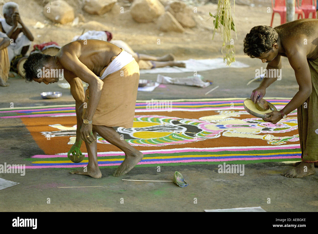Two artists drawing Kalam, a floor design during a ritual in a temple ...