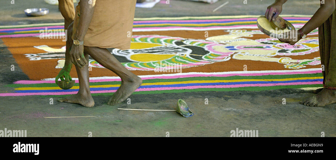 Two artists drawing Kalam, a floor design during a ritual in a temple ...
