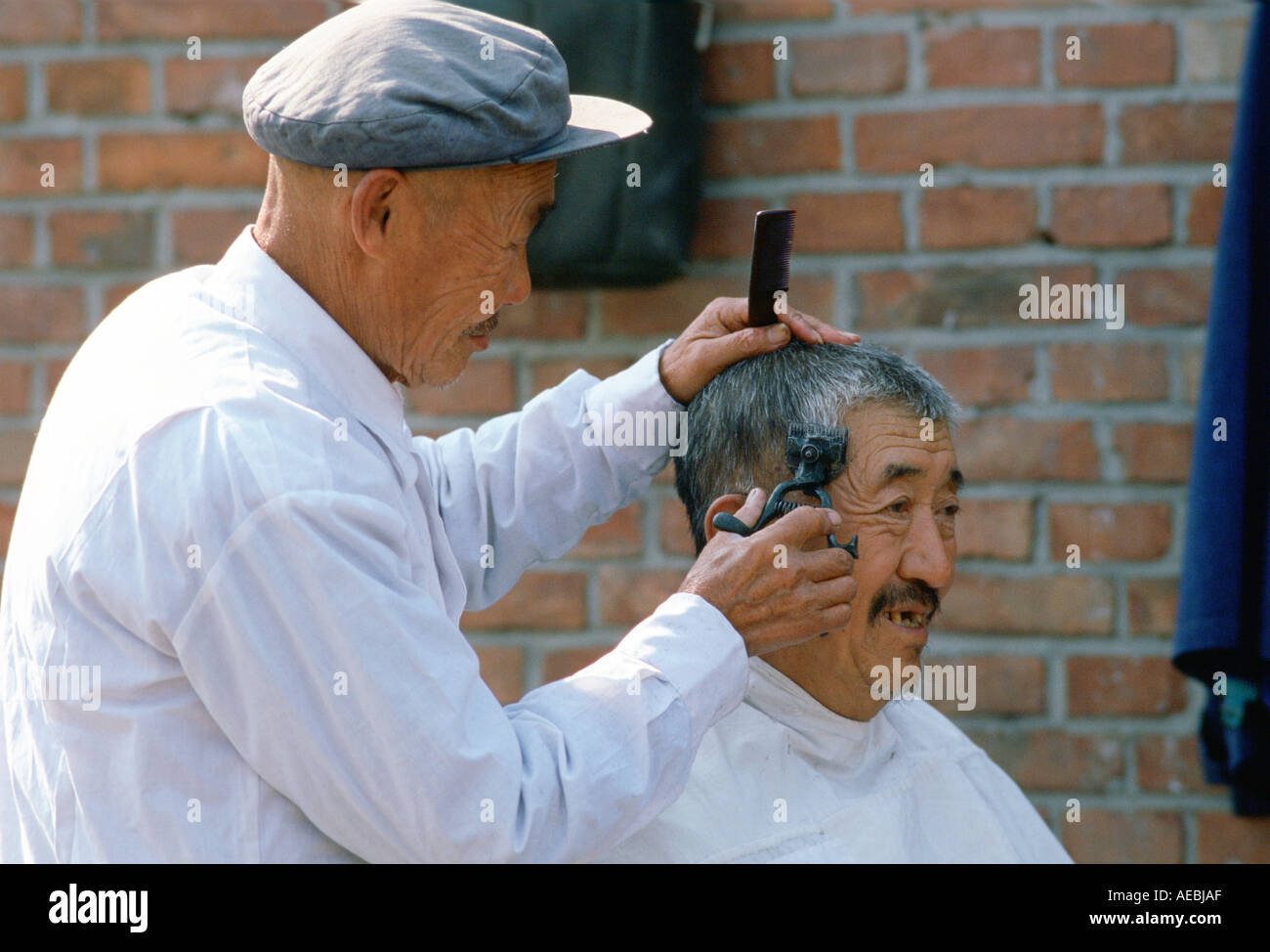 Barber cutting hair china hi-res stock photography and images - Alamy