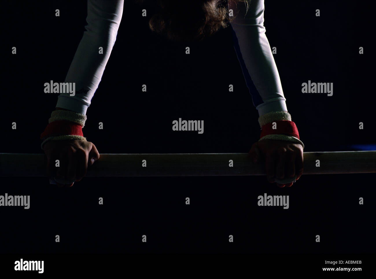 A gymnast grips the uneven parallel bars during a competition Stock ...