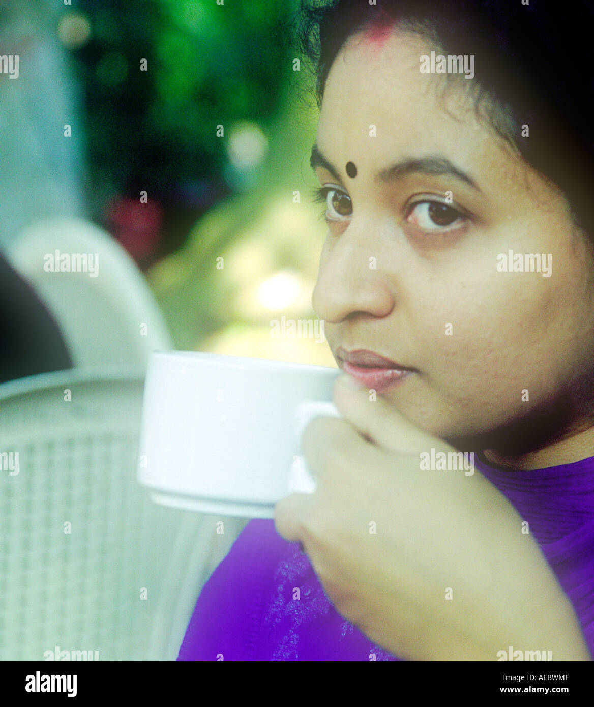 A young Indian lady sipping tea Stock Photo - Alamy