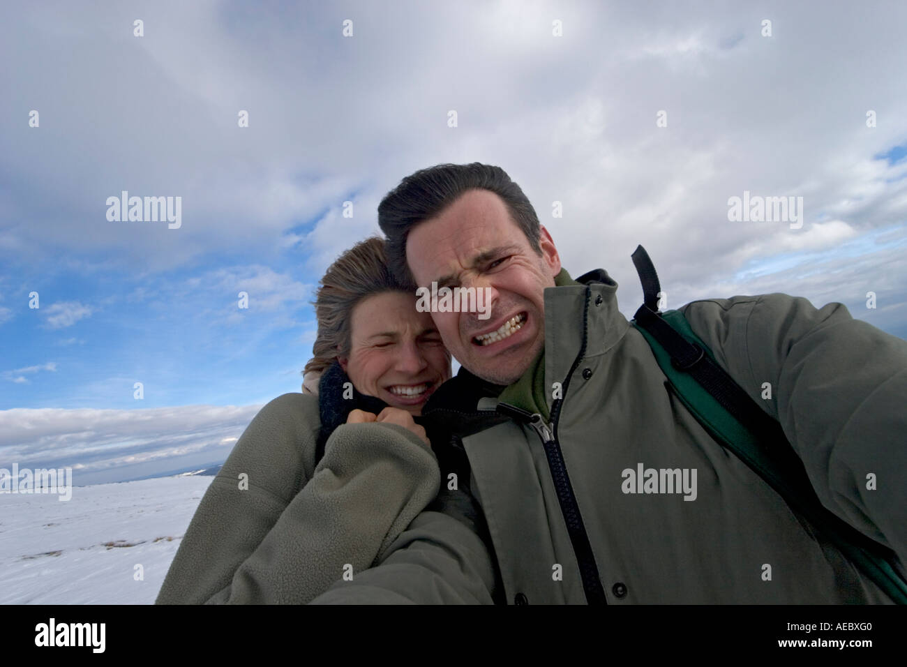 In the Sancy Massif, couple fighting against the wind (France). Couple ...