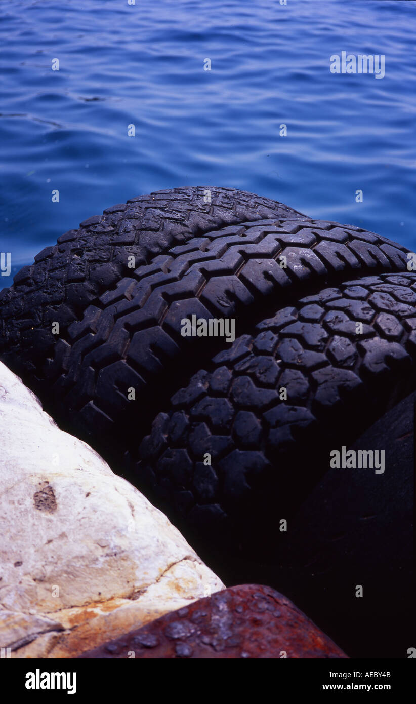 A group of tyres are hung on the edge of a dock in the Adriatic sea ...