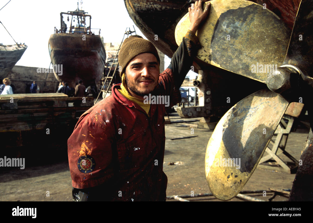 A harbour worker poses by the propeller of a trawler in the Moroccan ...