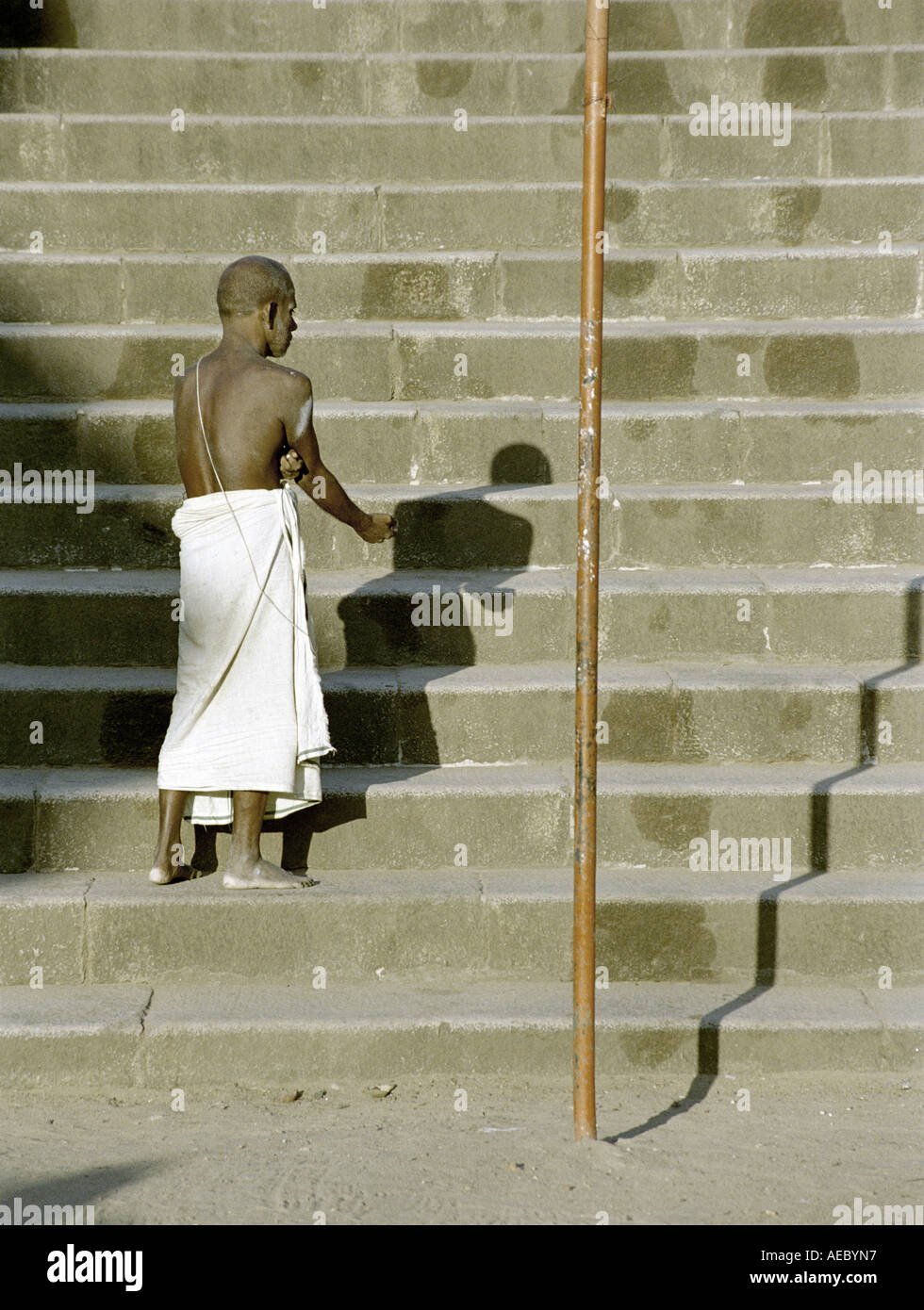Conceptual image of an old man standing still on steps with a pole and ...