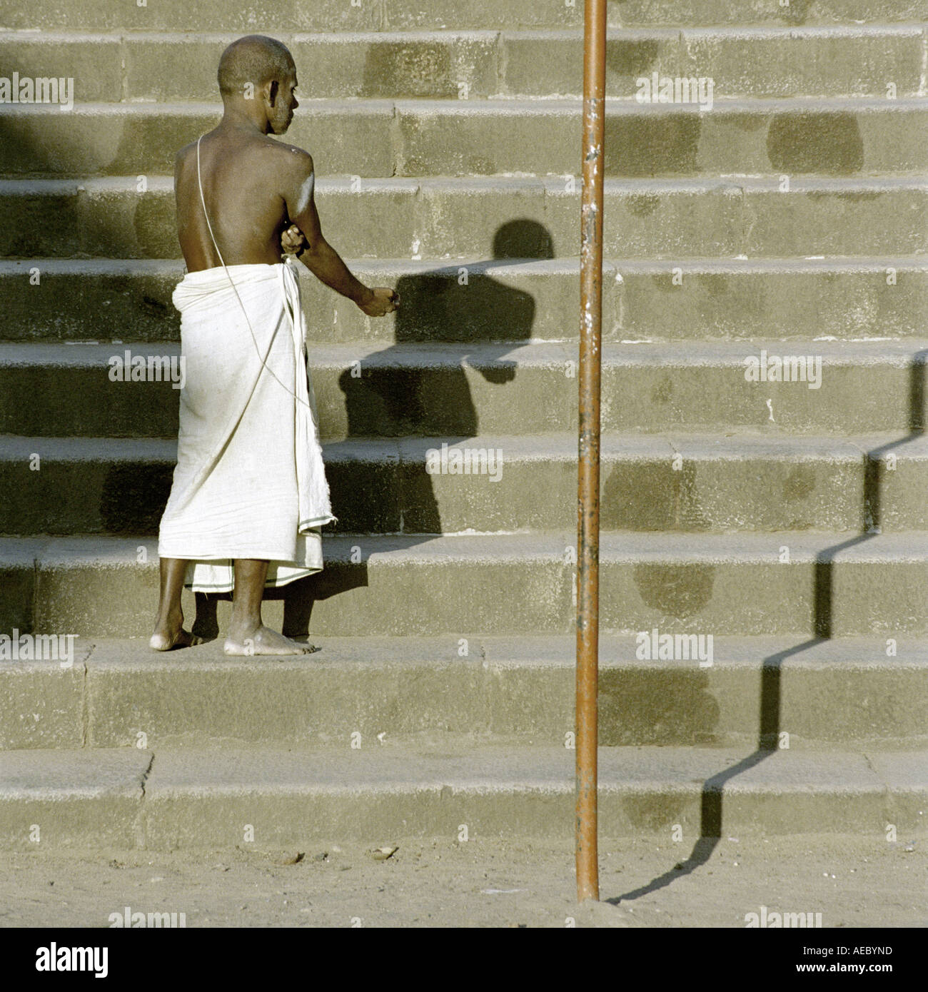 Conceptual image of an old man standing still on steps with a pole and ...